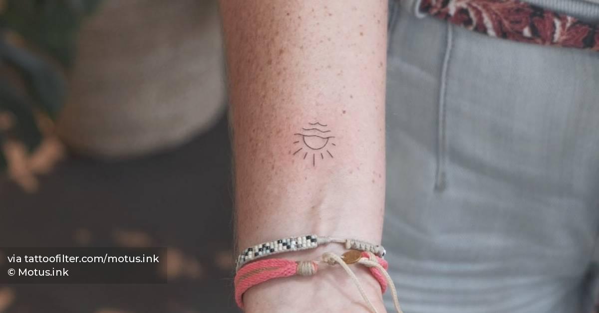 Minimalist sunset tattoo on the wrist.