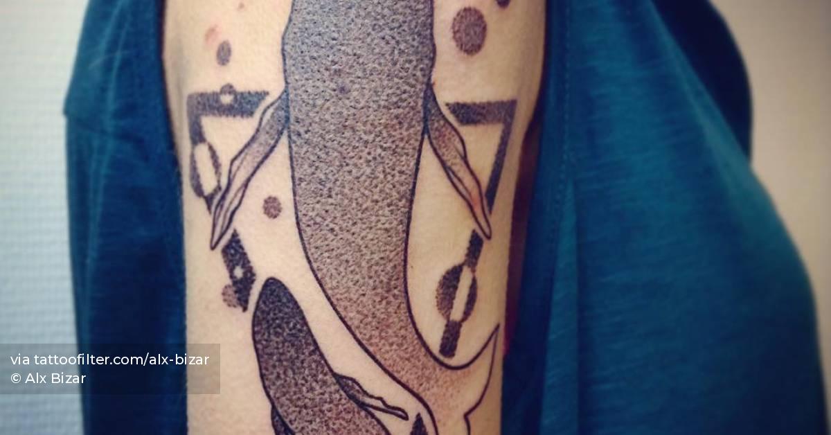 Dotwork whale tattoo on the upper arm.