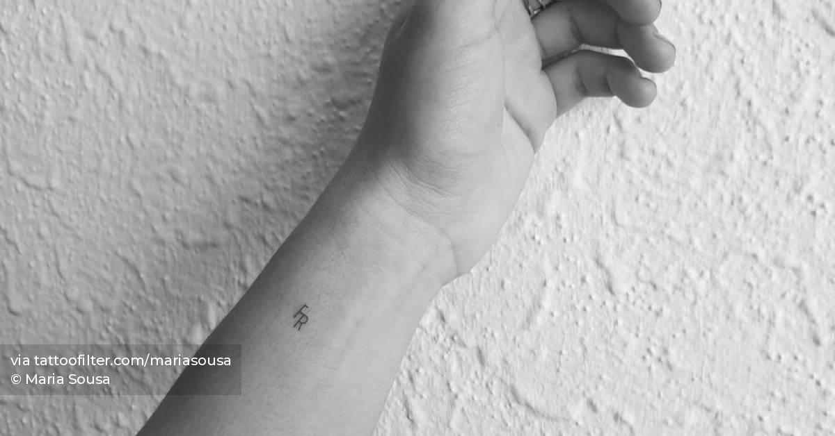 Initials lettering tattoo on the wrist.