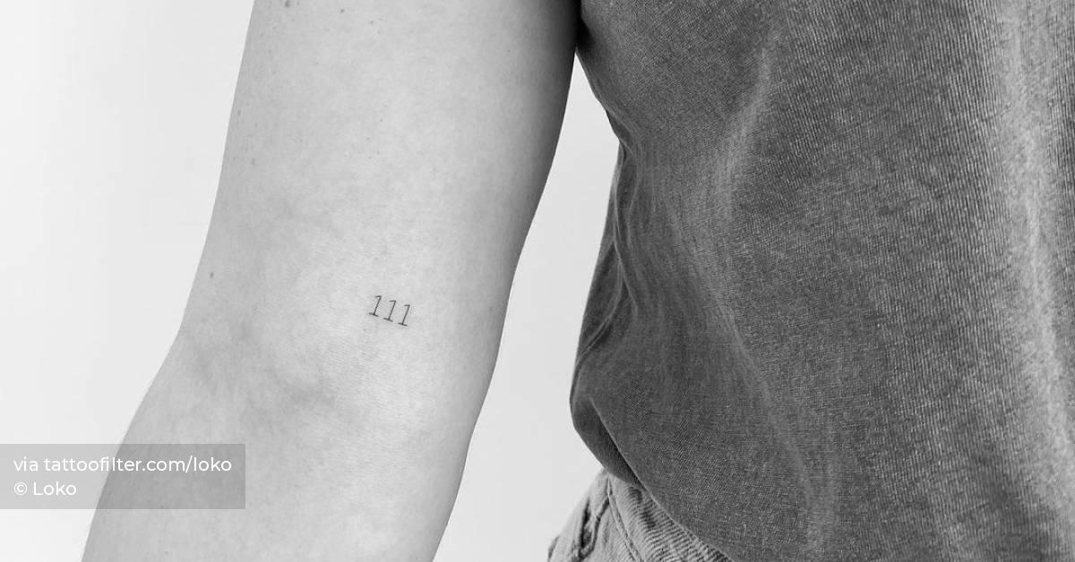 "111" lettering tattoo on the inner arm.