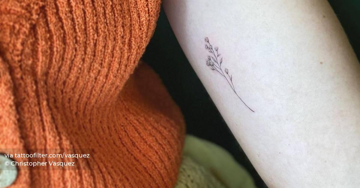 Fine line flower tattoo on the inner arm.