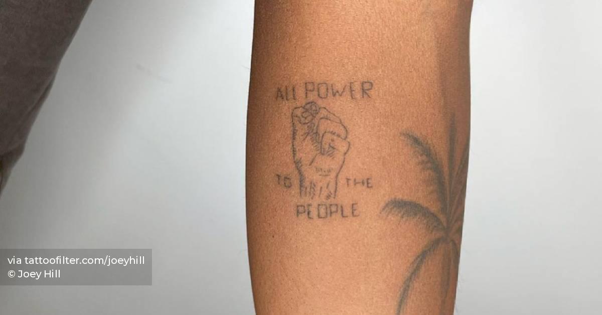 "All power to the people" tattoo on the inner forearm