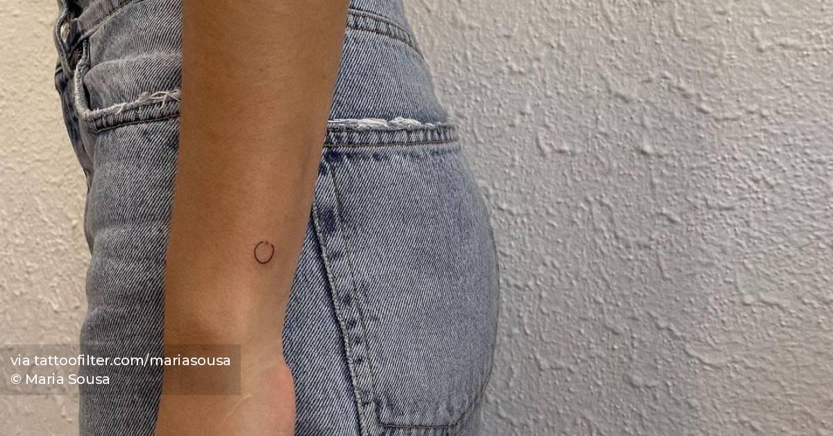 Minimalist circle tattoo on the wrist.