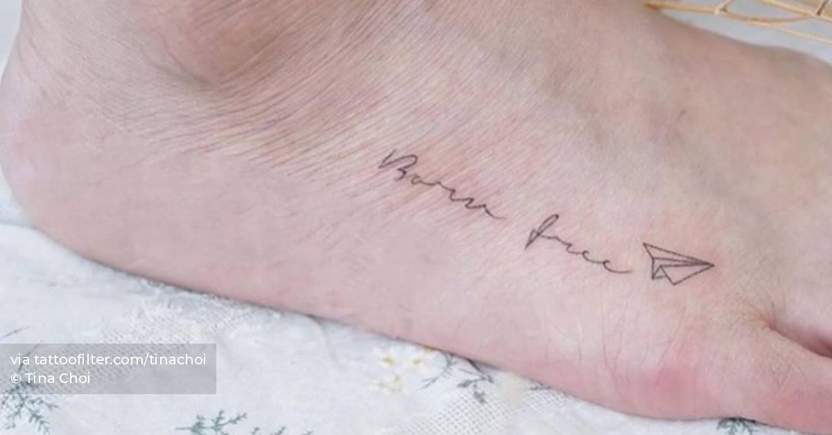 "Born free" lettering tattoo on the foot.