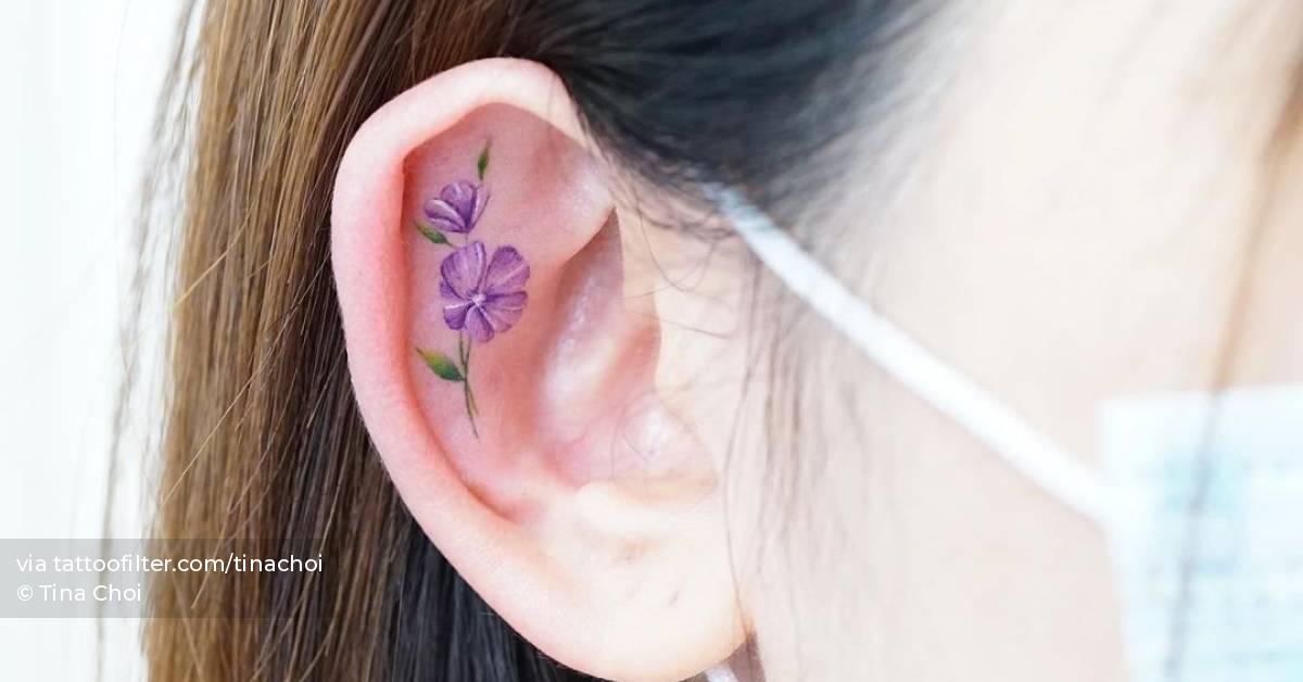 Watercolor flower tattoo on the ear.