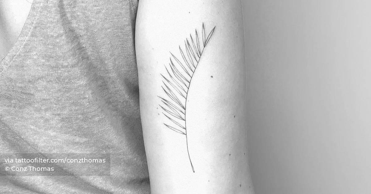 Fine line palm leaf tattoo on the tricep.