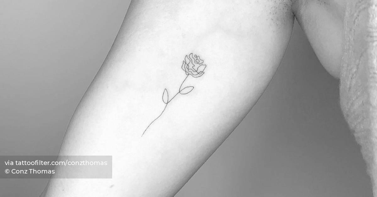 One line rose tattoo on the inner arm.