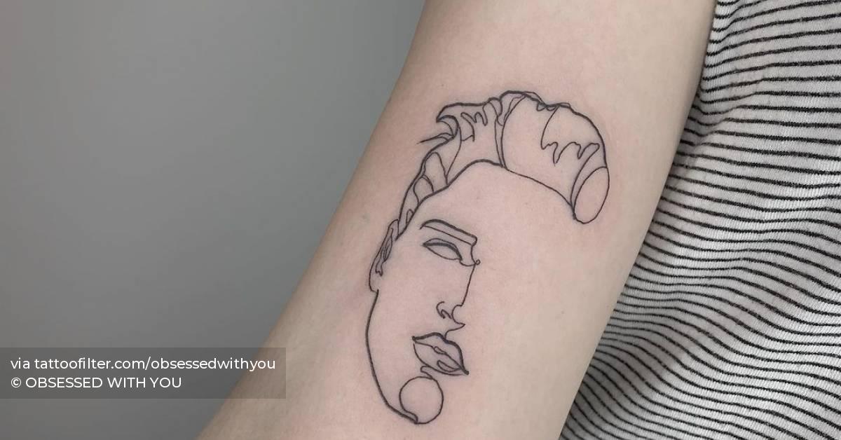 Line art Elvis portrait tattoo on the bicep.