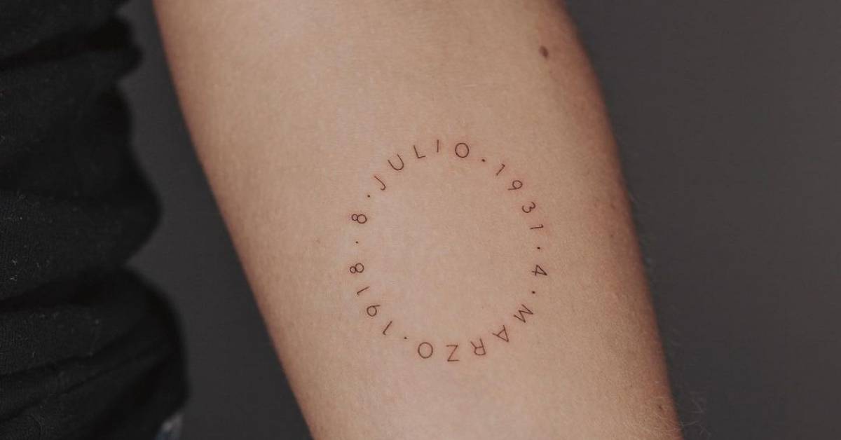 Dates in writing tattoo on the inner forearm.