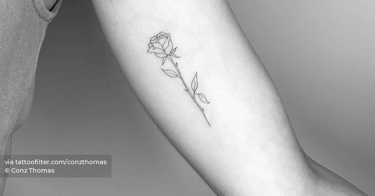 Fine line rose tattoo on the inner arm.