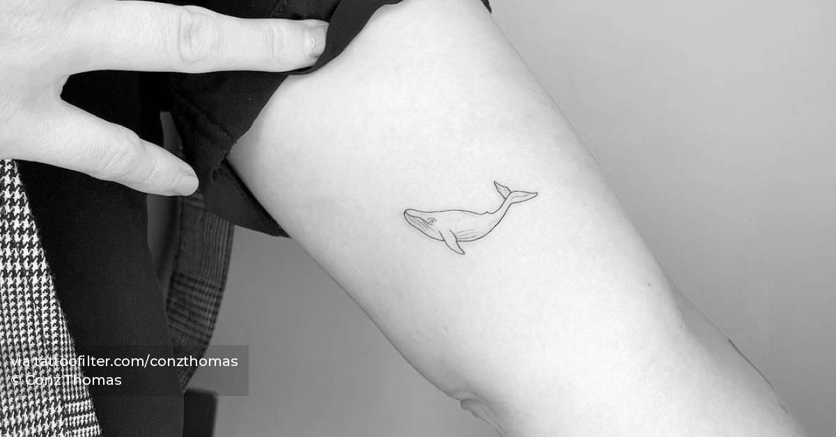 Fine line whale tattoo on the inner arm.