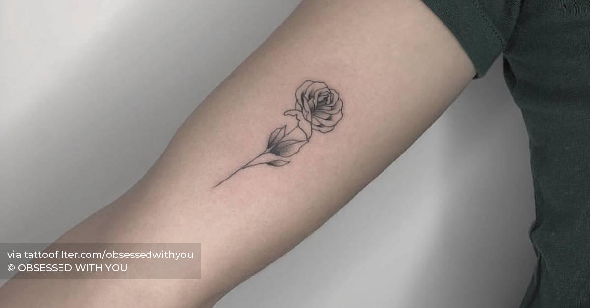 FIne line rose tattoo on the inner arm.
