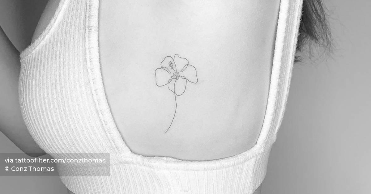 One line flower tattoo on the side boob.