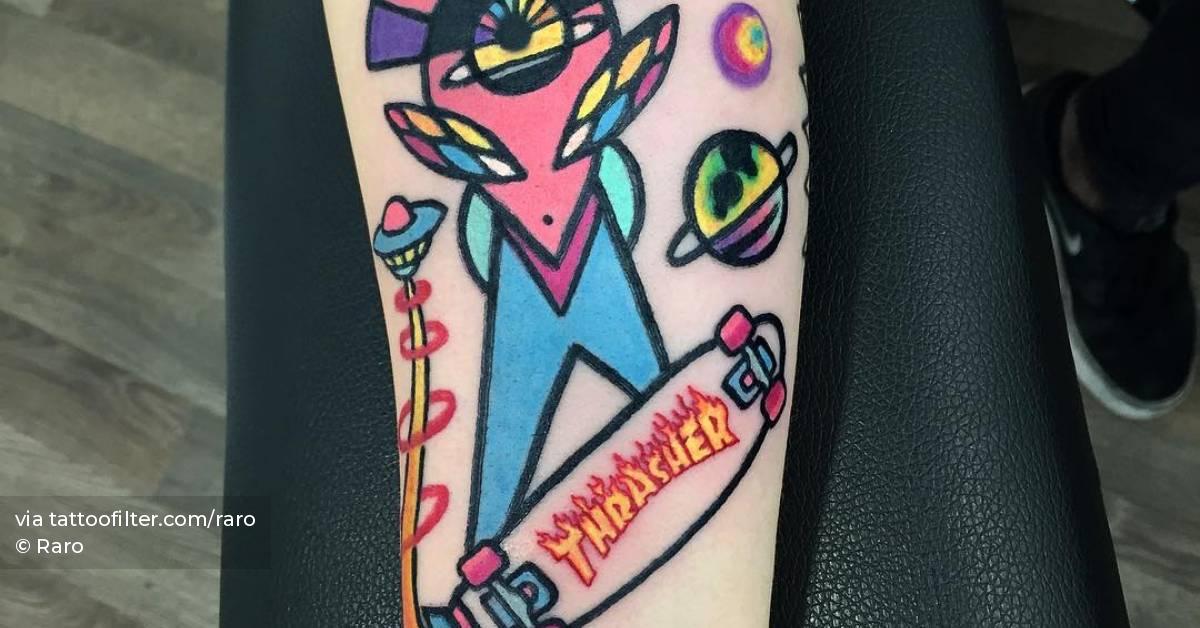 Pop art alien skateboarder tattoo on the inner arm.