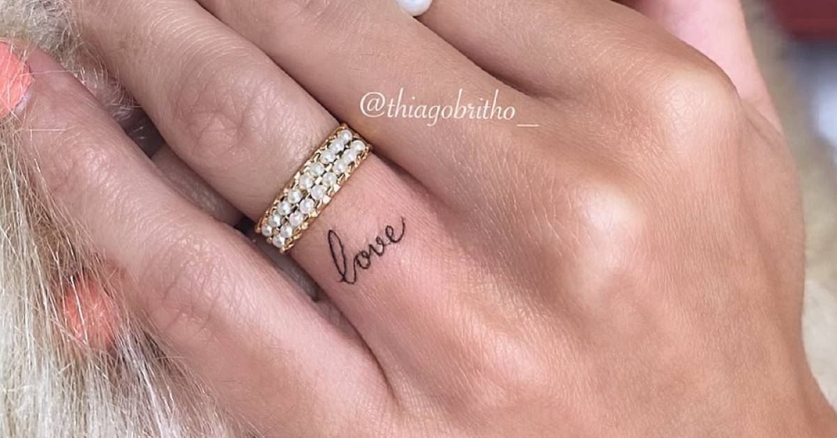 "Love" lettering tattoo on the finger.