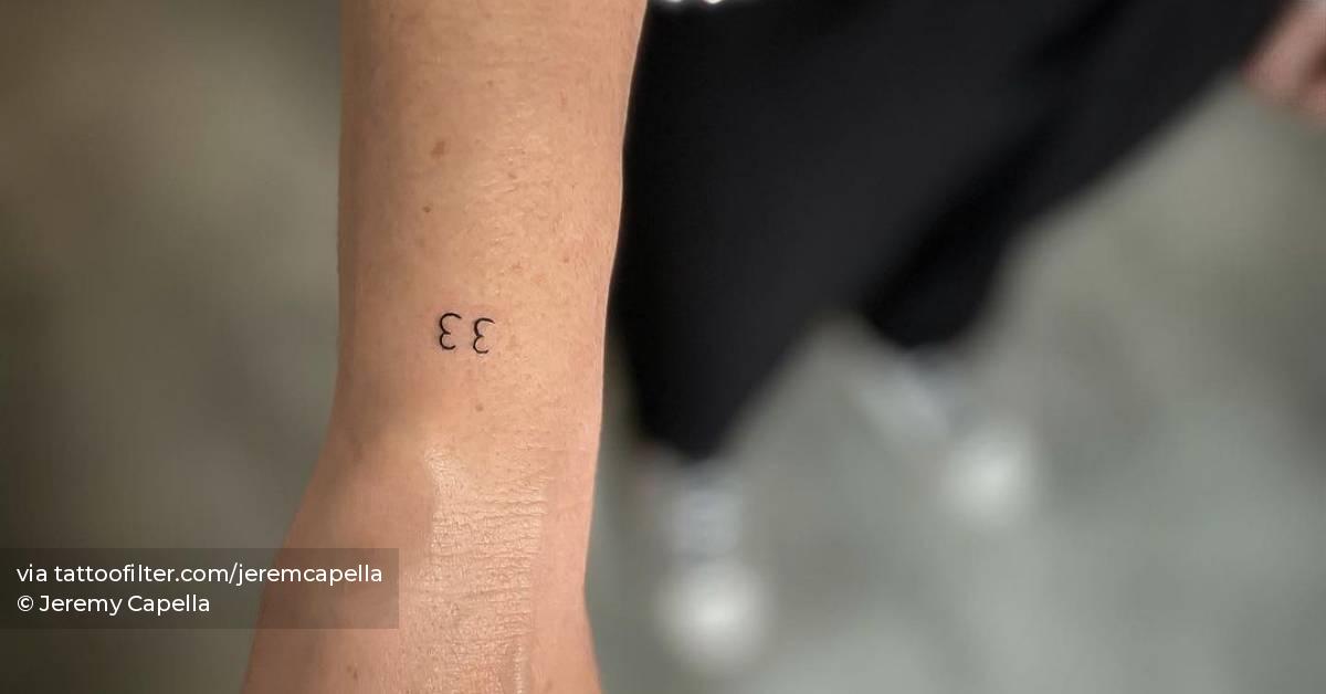 "33" lettering tattoo on the wrist.