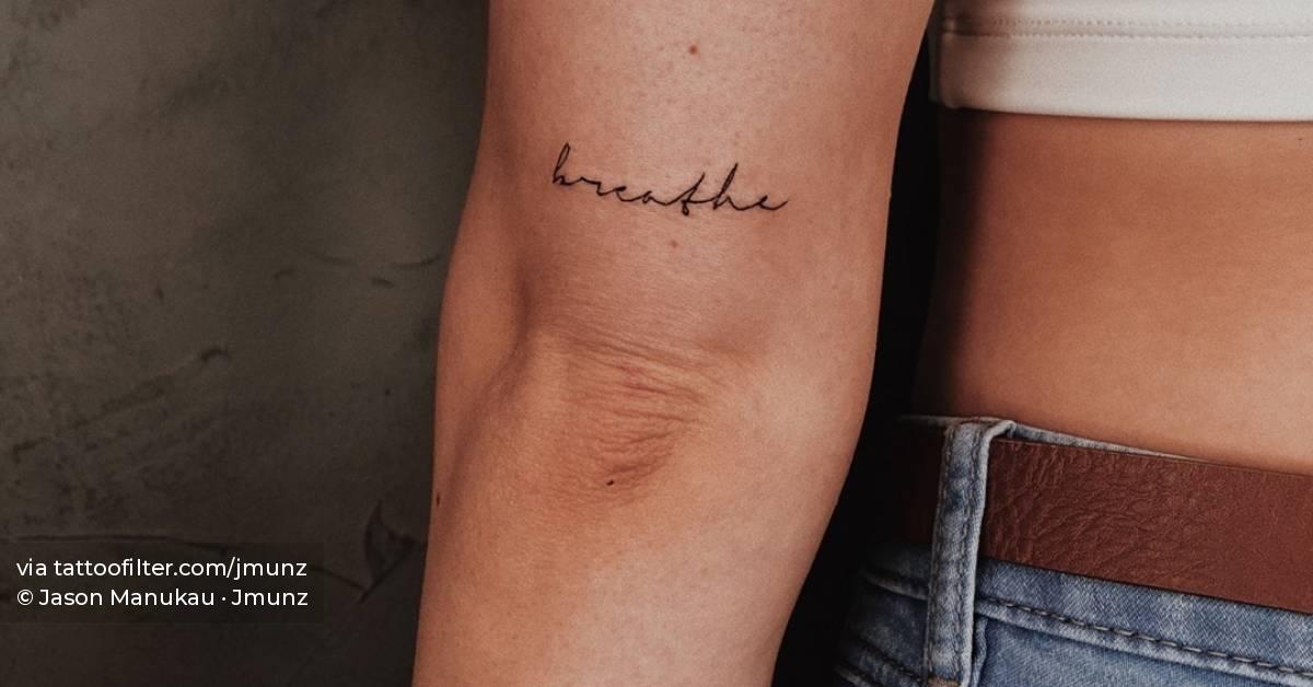 “Breathe” lettering tattoo on the tricep.