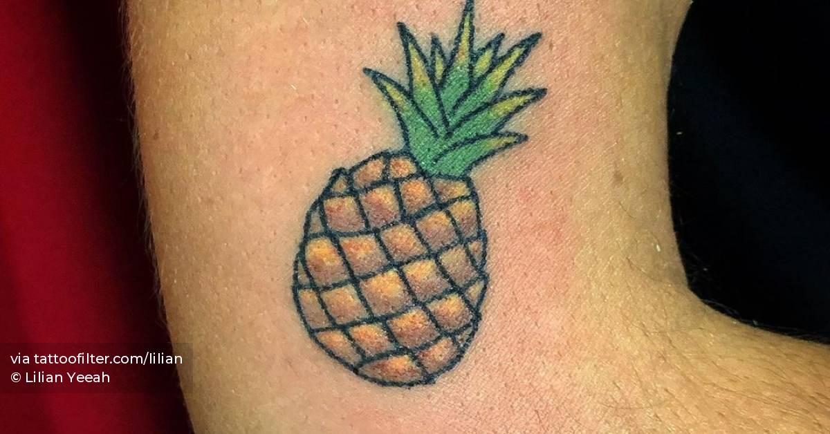 Hand poked pineapple tattoo on the upper arm.