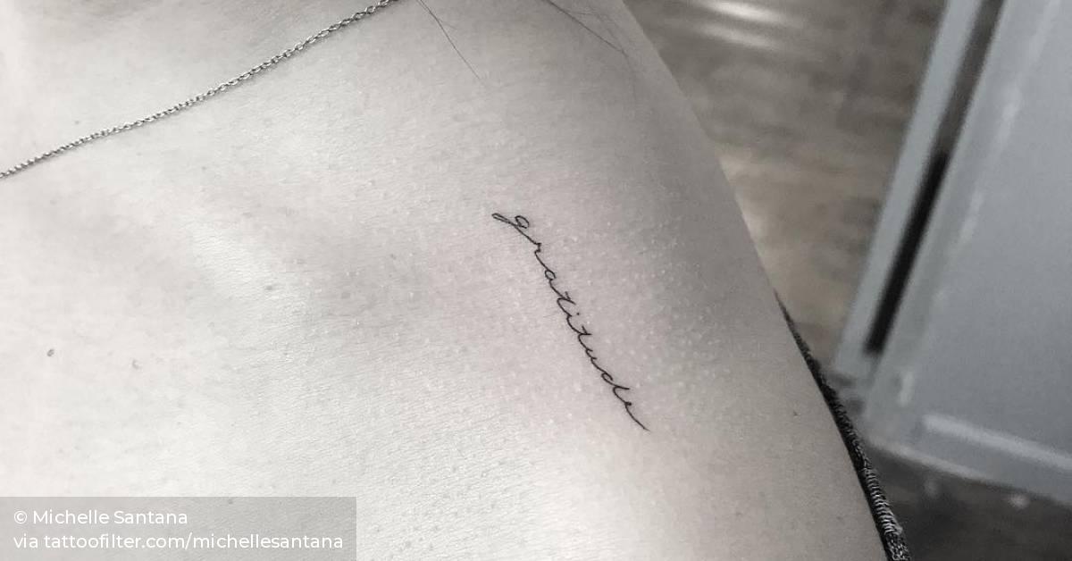 “Gratitude” tattoo on top of the left shoulder.
