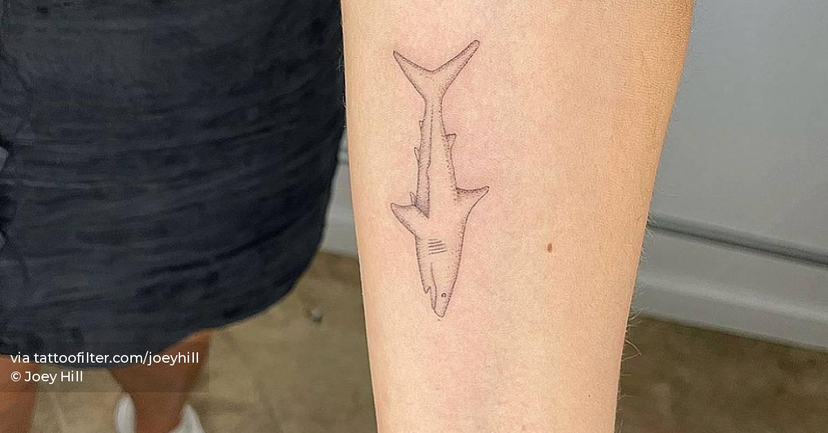Fine line shark tattoo on the inner forearm.