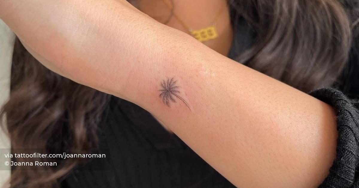 Fine line palm tree tattoo on the wrist.