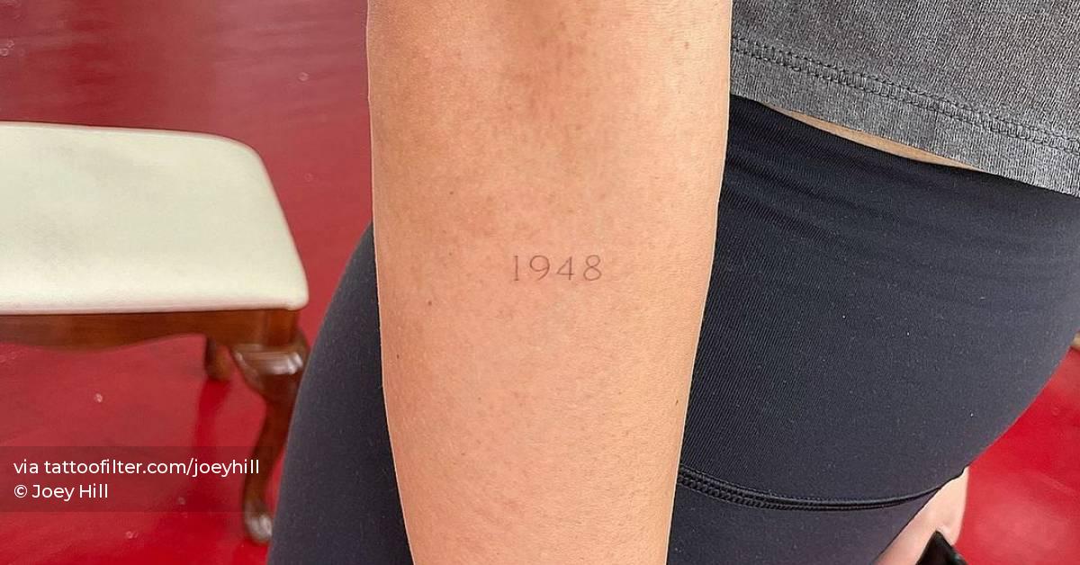 "1948" lettering tattoo on the forearm.