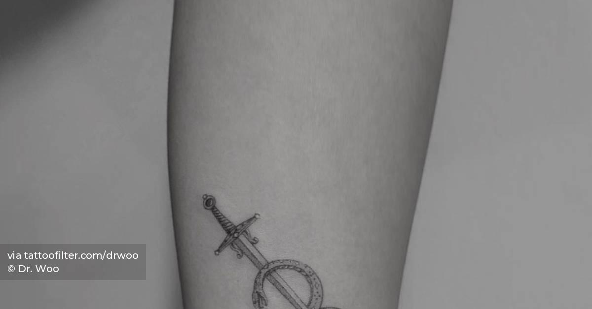 Sword and ouroboros tattoo on Rita Ora's inner forearm.