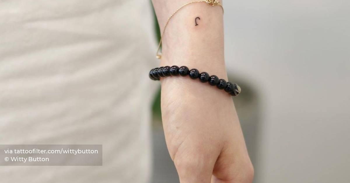 Minimalist letter "J" tattoo on the wrist.