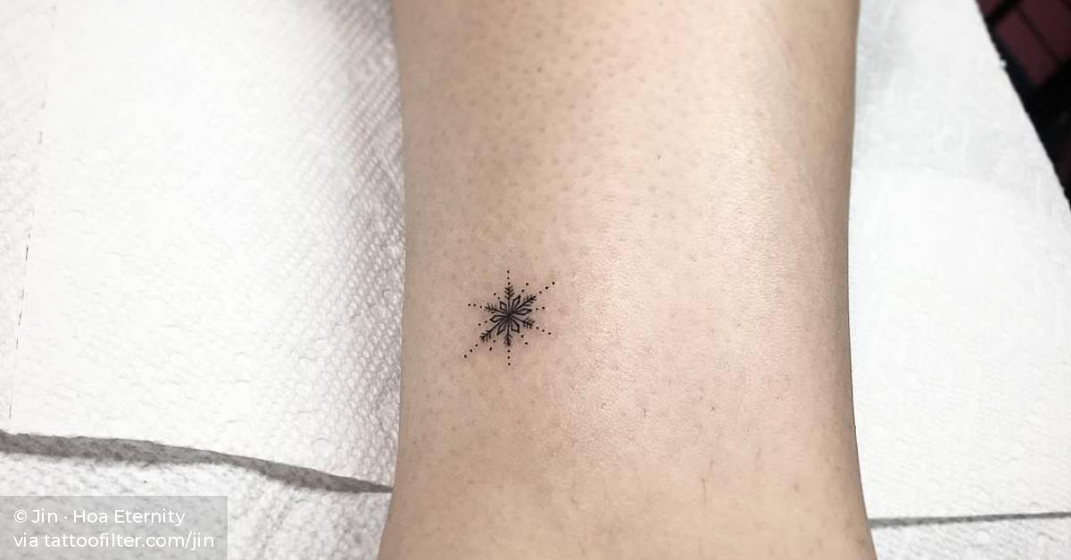Minimalist snowflake tattoo on the ankle.