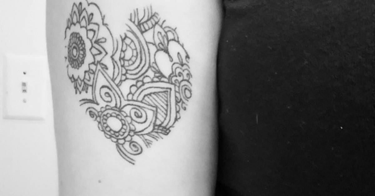 Bicep tattoo of a heart on Kat.