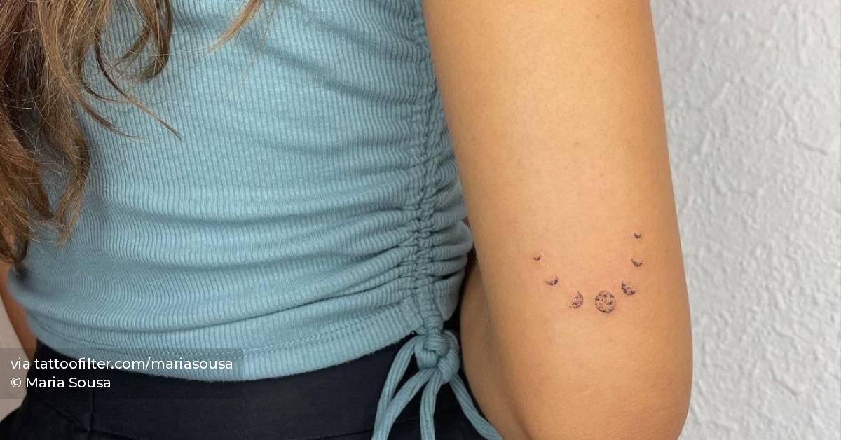 Fine line moon phases tattoo on the tricep.