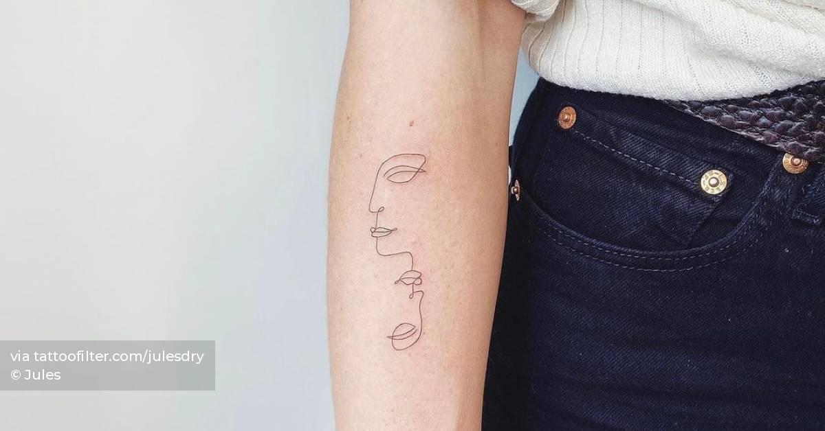 One line faces tattoo on the forearm.