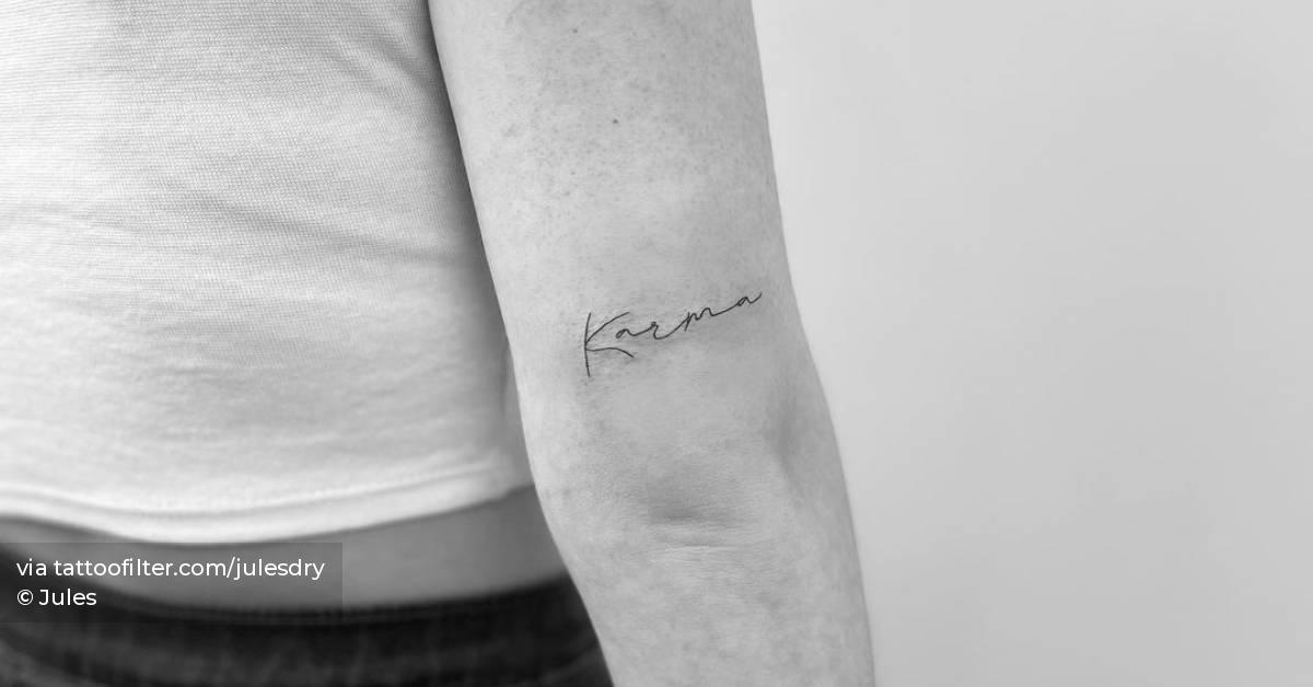 "Karma" lettering tattoo on the tricep.