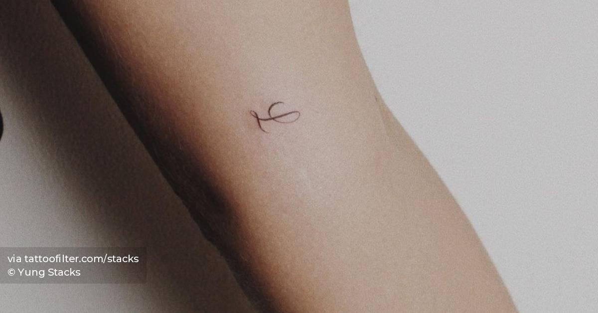 Minimalist letter "L" tattoo on the inner arm.