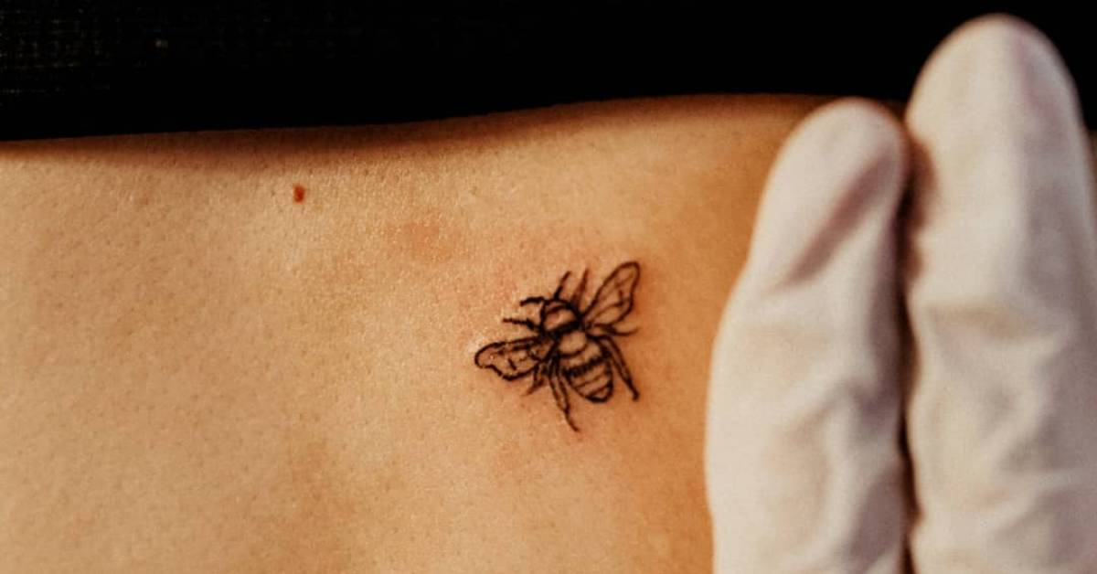 Fine line bee tattoo on the back.
