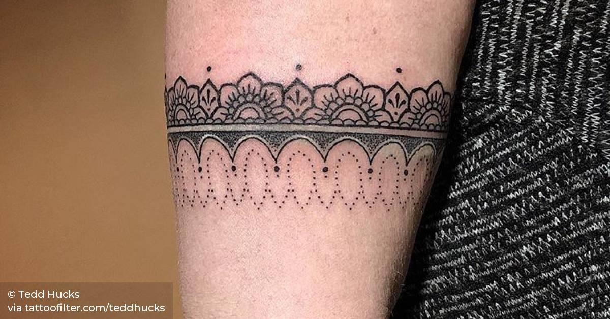 Ornamental armband tattoo on the right upper arm.