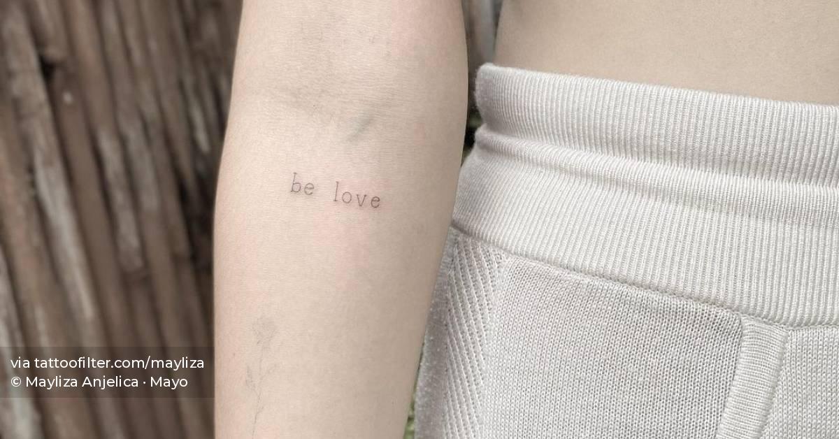 "Be love" lettering tattoo on the inner forearm.