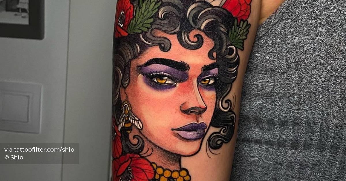 Neotraditional woman portrait tattoo on the upper arm.