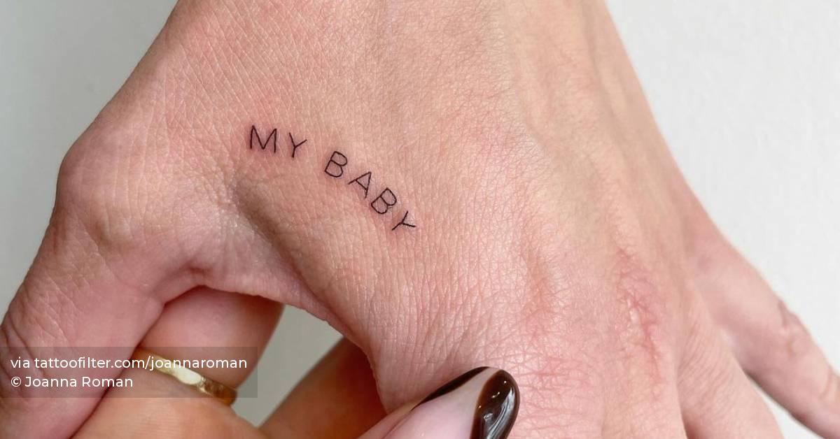 "My baby" lettering tattoo on the hand.