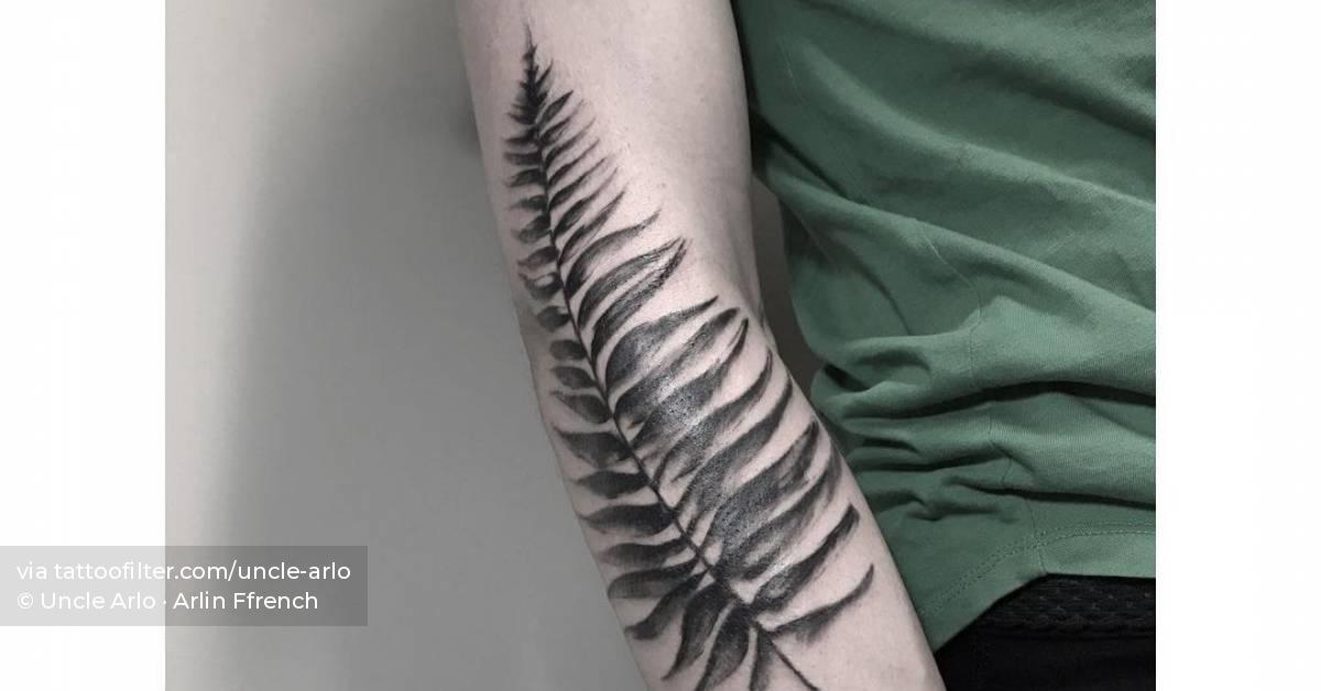 Watercolor fern frond tattoo on the arm.