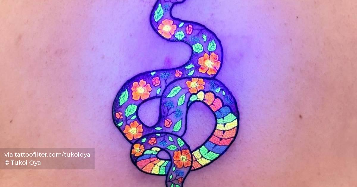 UV Ink snake tattoo on the lower back.