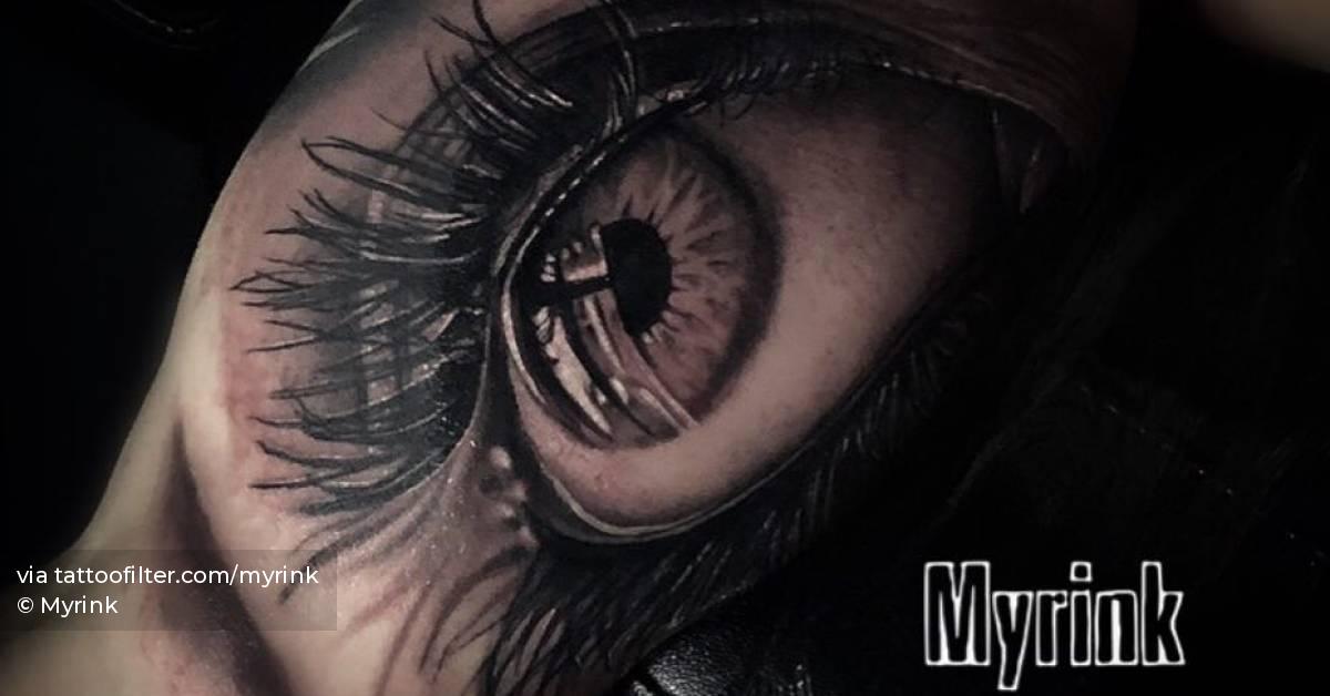 Black and grey eye tattoo on the inner arm.