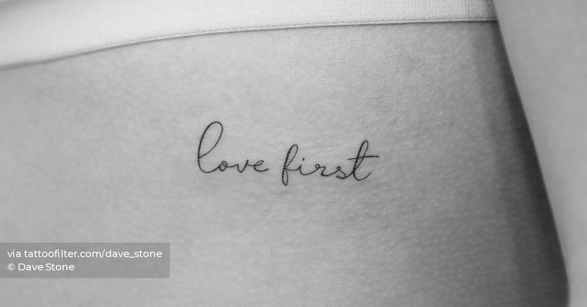 "Love First" lettering tattoo on the rib.