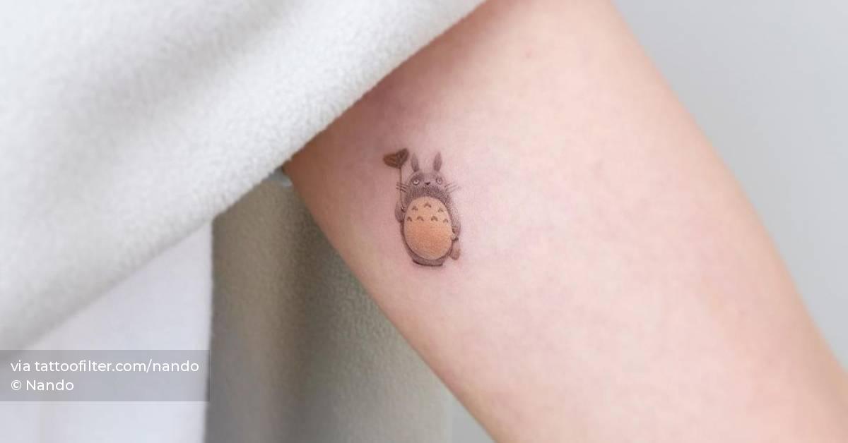 Totoro tattoo on the inner arm.