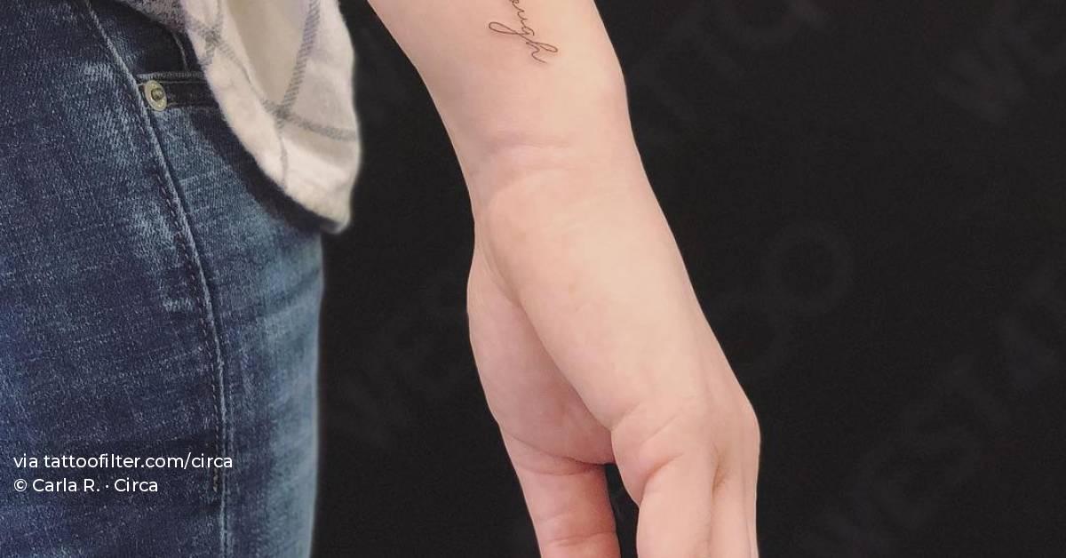 "Enough" lettering tattoo on the wrist.