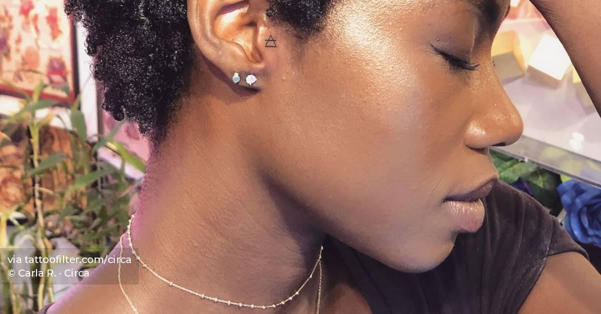 Minimalist Transcend symbol tattoo on the ear.