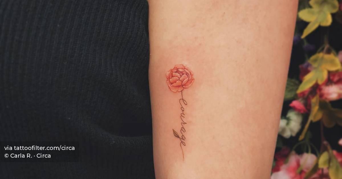 Pink peony and "courage" tattoo on the bicep.