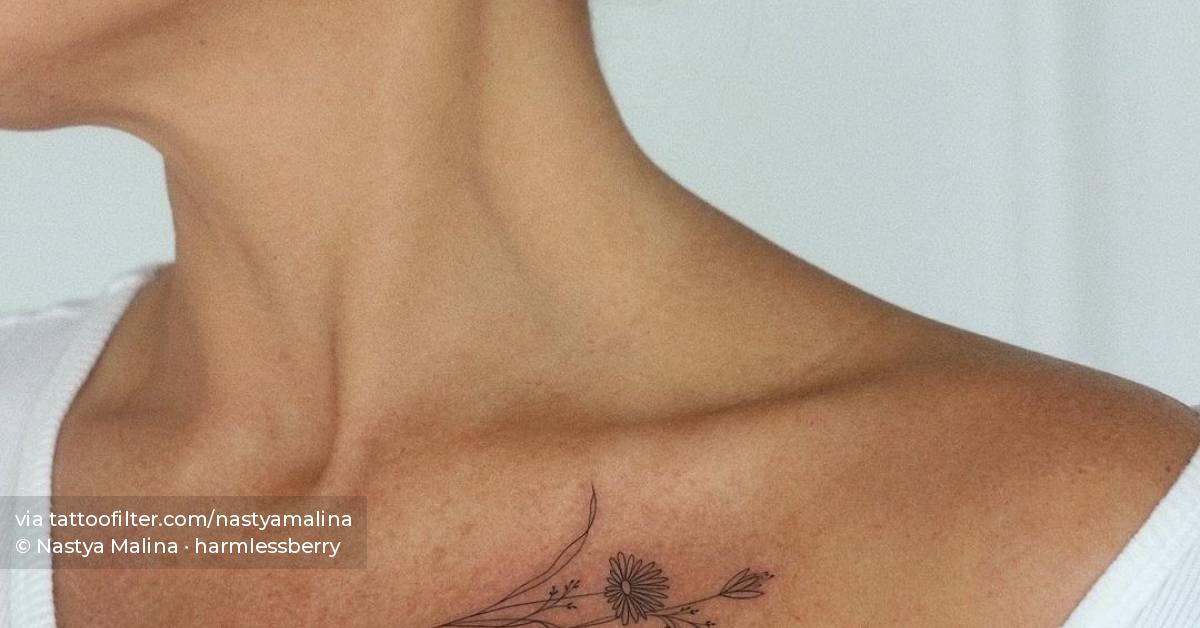 Fine line flowers tattoo on the collarbone.