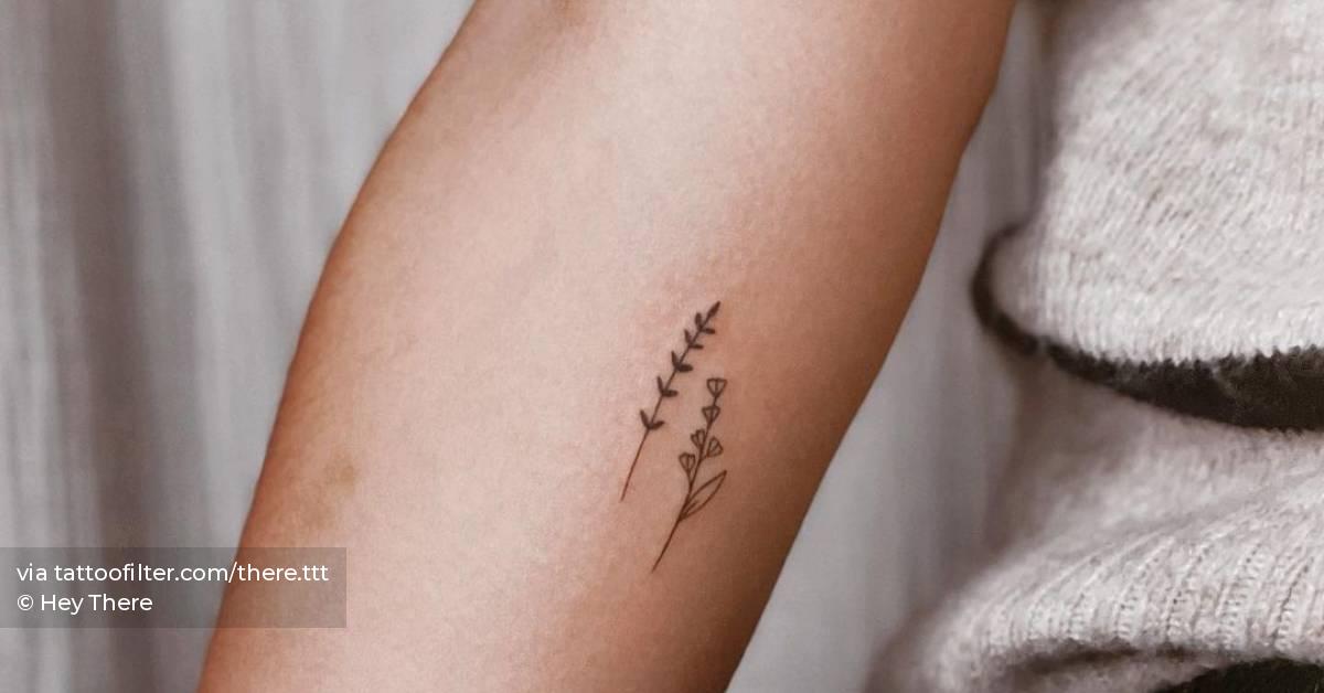 Fine line lavender tattoo on the inner forearm.