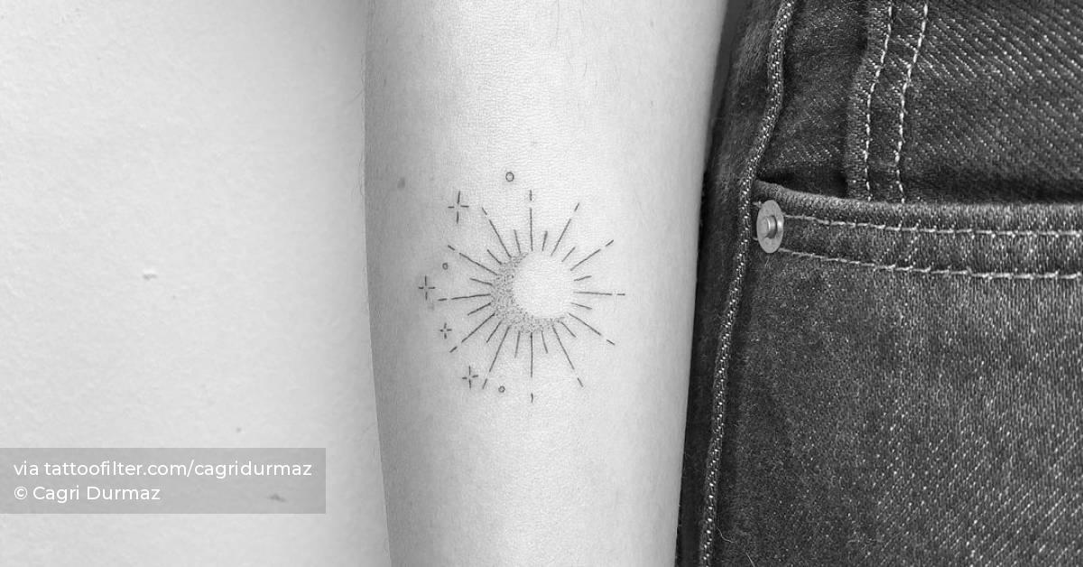 Fine line sun and moon tattoo on the inner forearm.